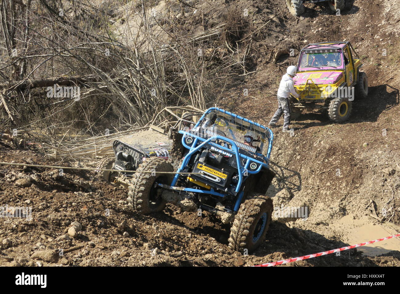 Co-driver of off-road car is pulling steel wire, all-terrain vehicle is ...