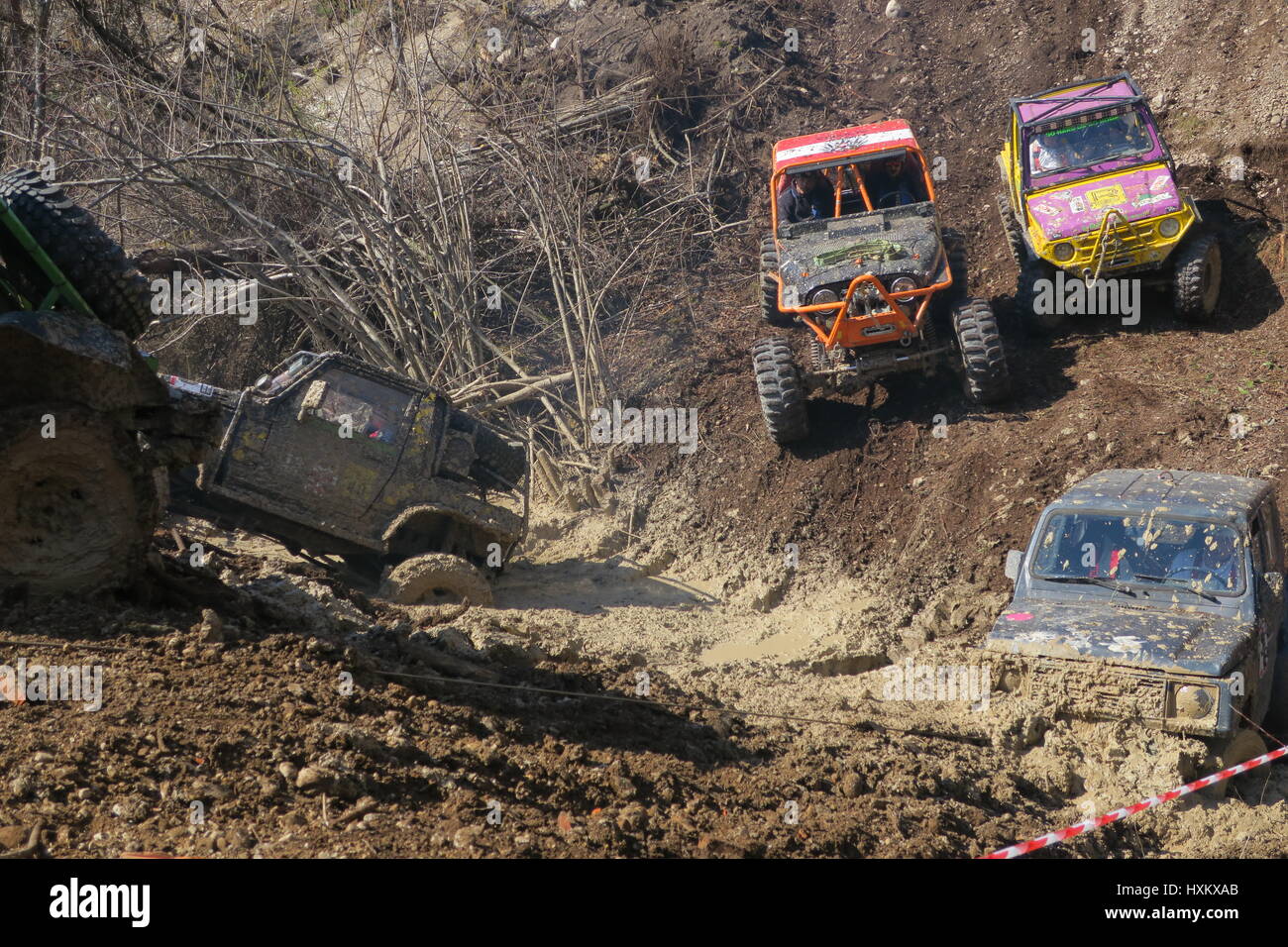An off-road car got stuck in a muddy trench, fixed by steel wire at an ...