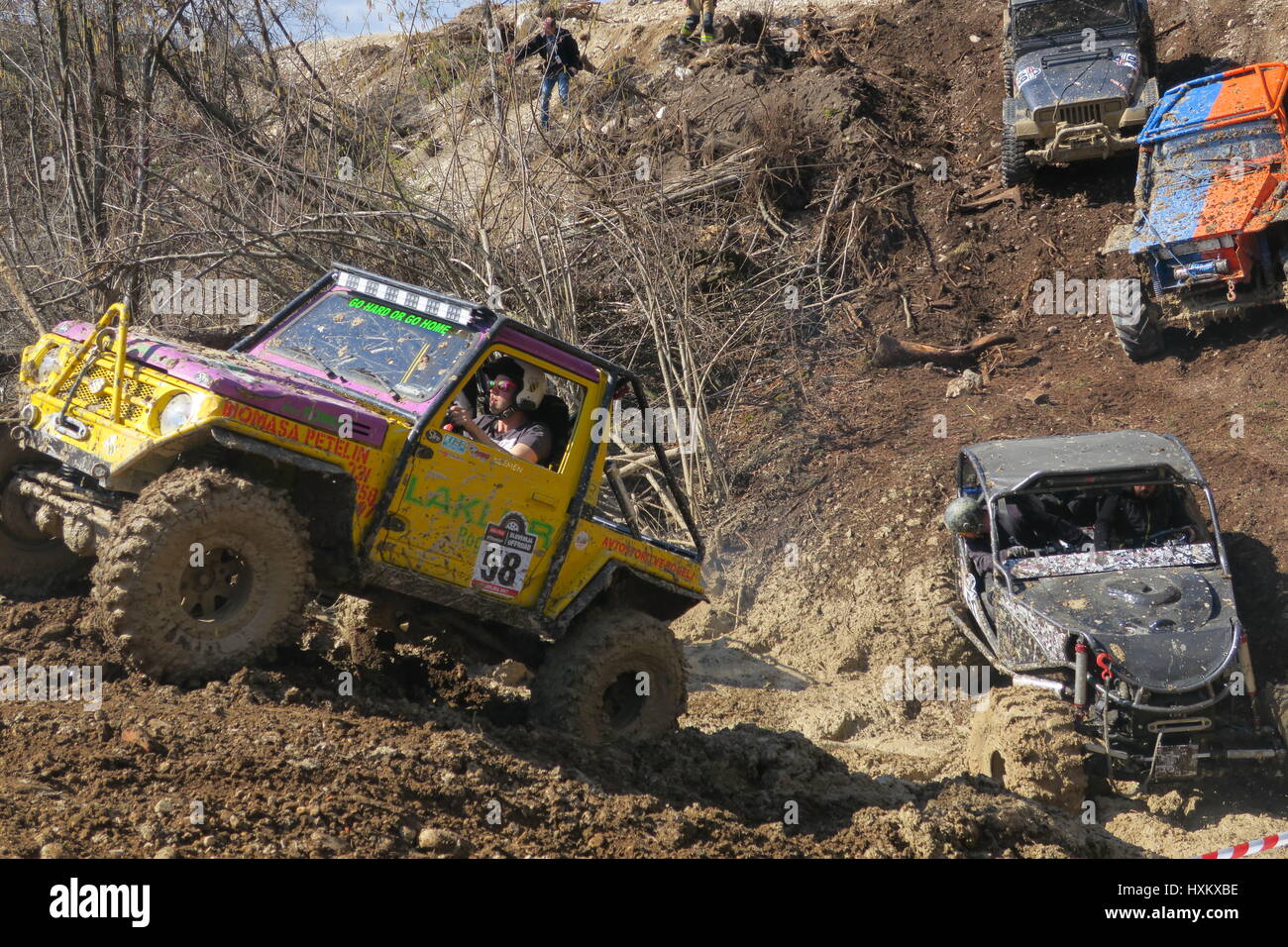 Off-road car is pulled uphill by hydraulics of an excavator, four-wheel ...