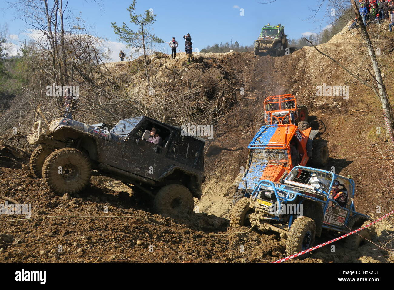 A off-road car is pulled uphill by hydraulics of an excavator, a four ...