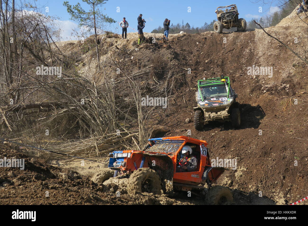 A off-road car is pulled uphill by hydraulics of an excavator, four ...
