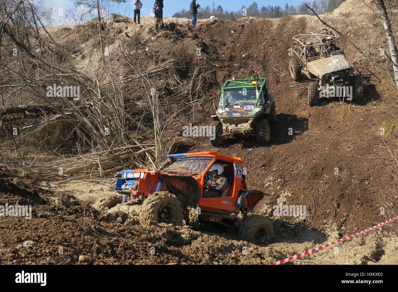 An off-road car is pulled uphill by hydraulics of an excavator, all ...