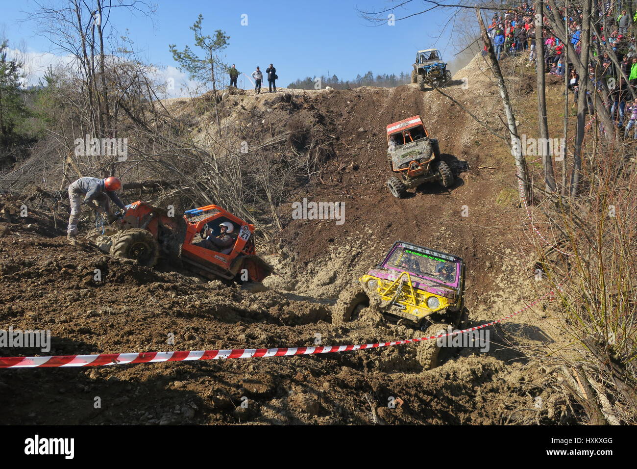 A co-driver is pulling steel wire of stuck off-road car, all-terrain ...