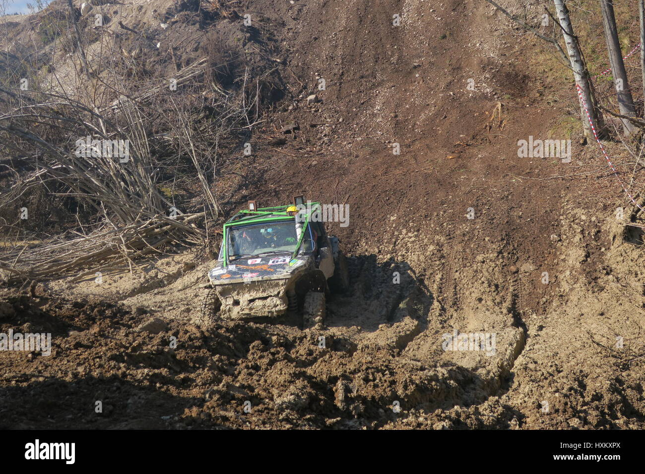 The off-road car gets stuck in a muddy trench at an off-road race in ...