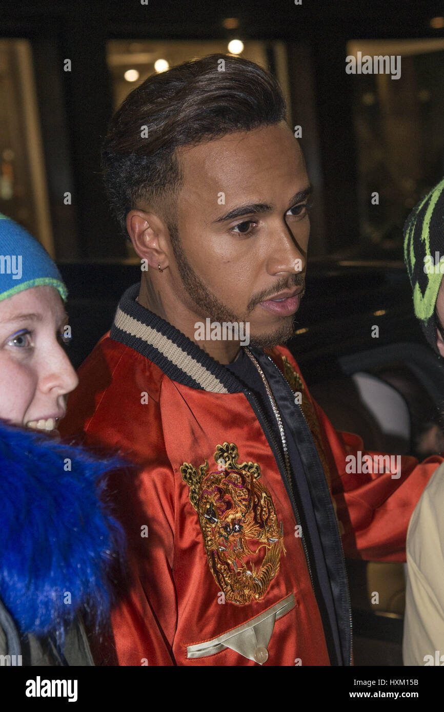 Lewis Hamilton poses for pictures with fans outside his hotel in Milan ...