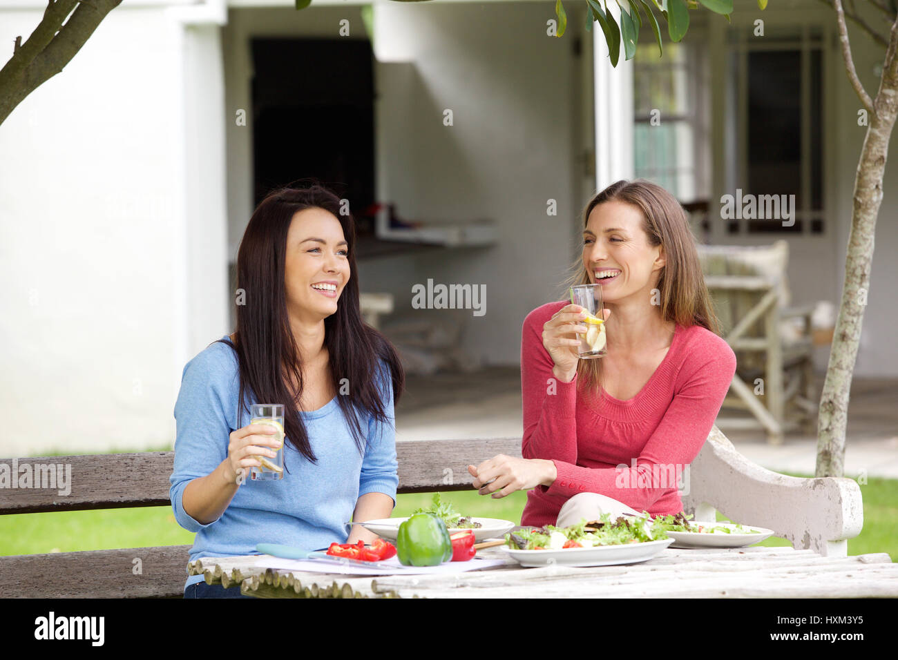 Portrait of two friends talking and having lunch together Stock Photo ...