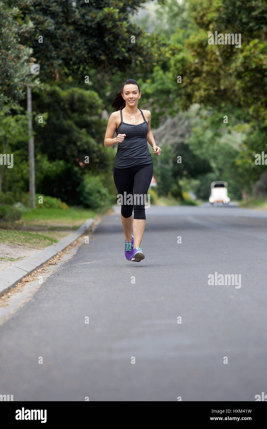 Full length portrait of a young woman running on street Stock Photo - Alamy