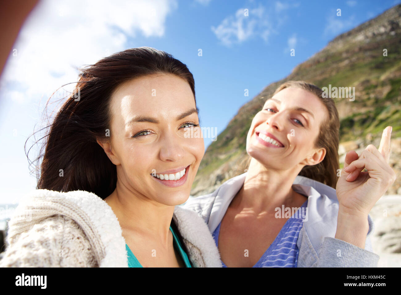 Two female friends smiling and taking selfie outdoors Stock Photo - Alamy