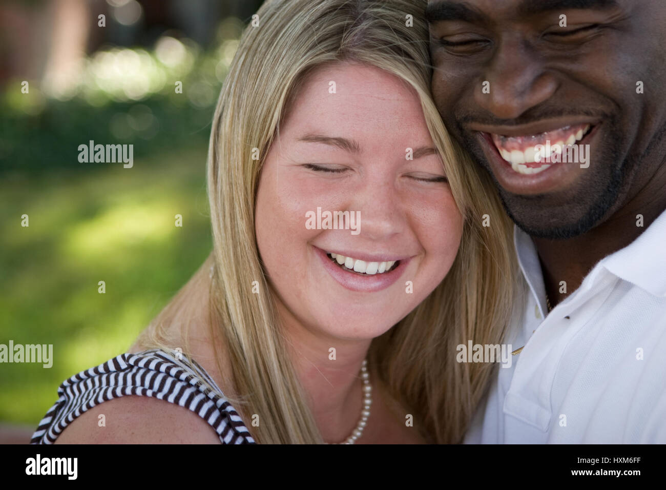 Loving multicultural couple hugging and smiling outside Stock Photo - Alamy