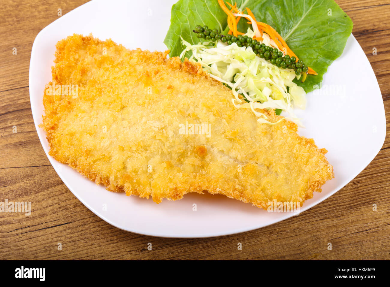 Fried Dory fish with salad on the wood background Stock Photo - Alamy