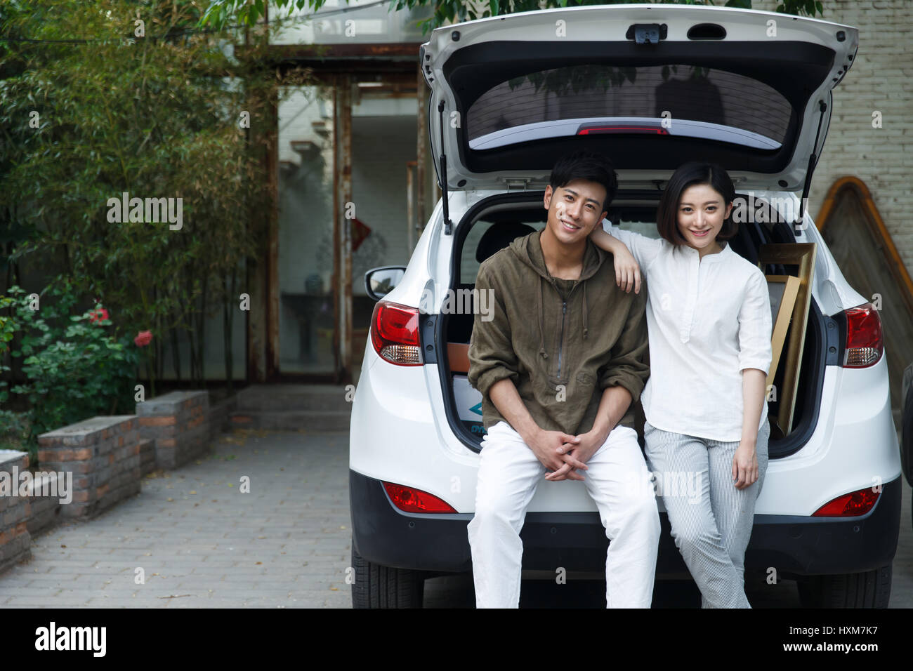 Young couple sitting in back of car Stock Photo - Alamy