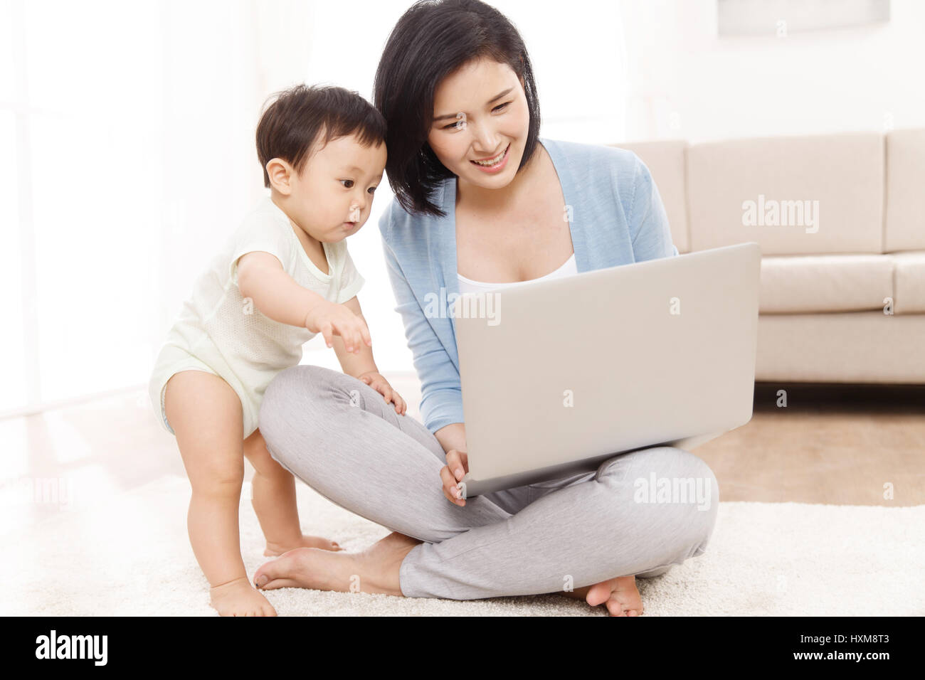 Mother and baby with laptop Stock Photo - Alamy