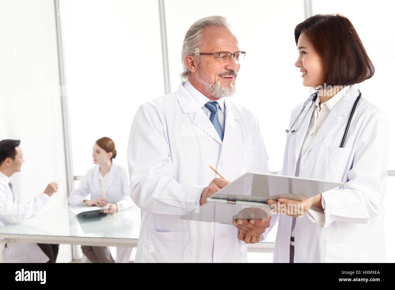 Doctors writing medical record Stock Photo - Alamy