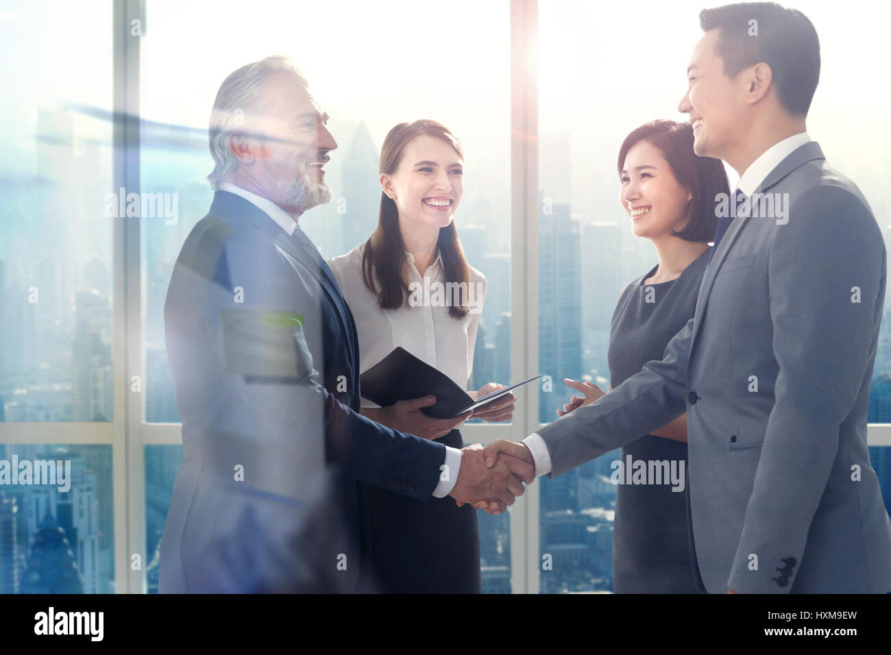 Authority smiling face to face shaking hands looking standing hi-res ...