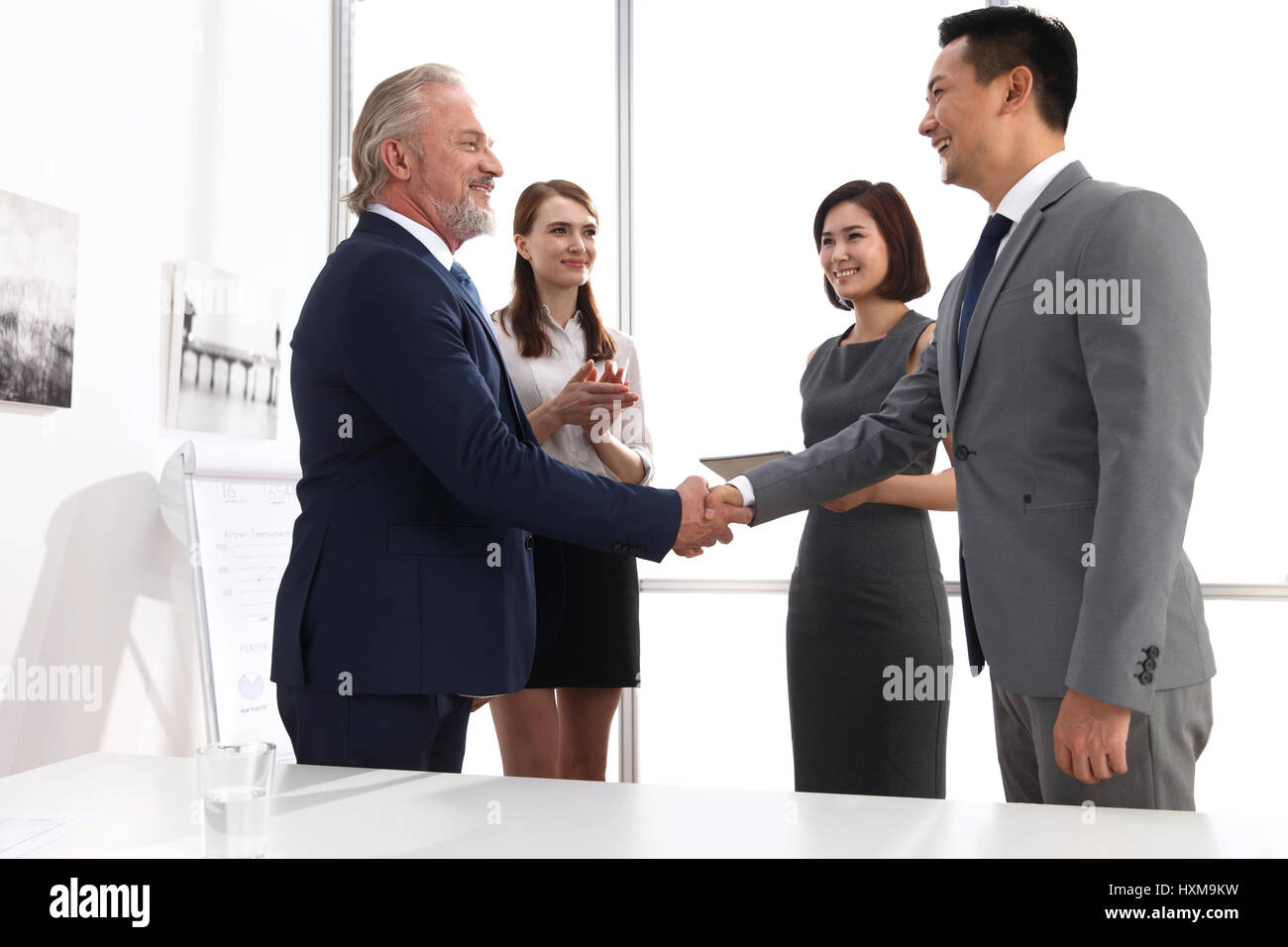 Standing shaking hands smiling face to face looking authority hi-res ...