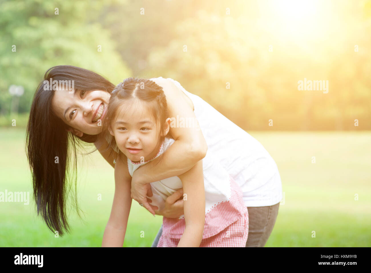 Mother and daughter hugging in love playing in the park. Mothers Day. Family outdoor fun ...