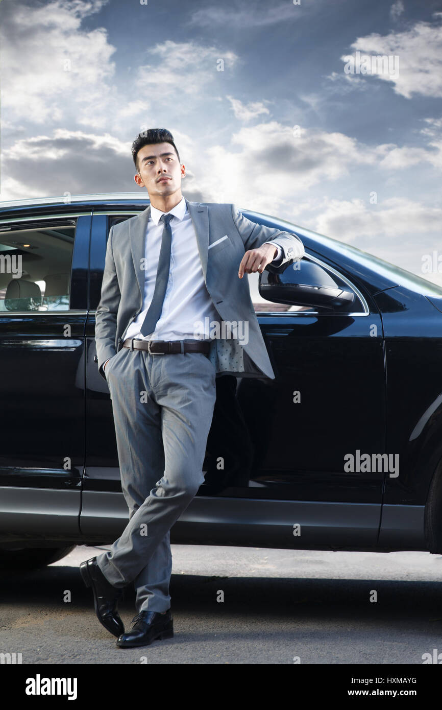 Young man standing by car Stock Photo - Alamy