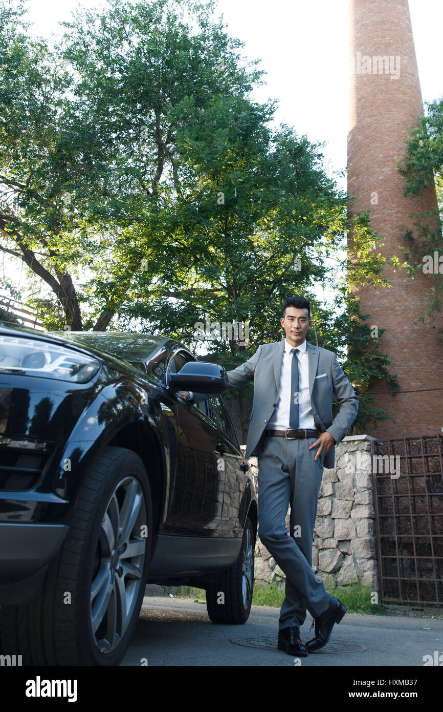 Young man standing by car Stock Photo - Alamy