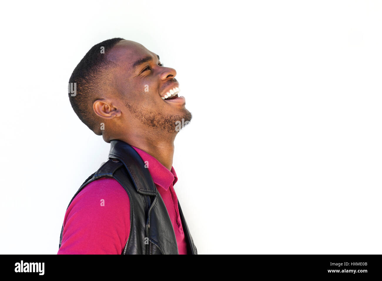 Close up side portrait of african young guy laughing against white ...