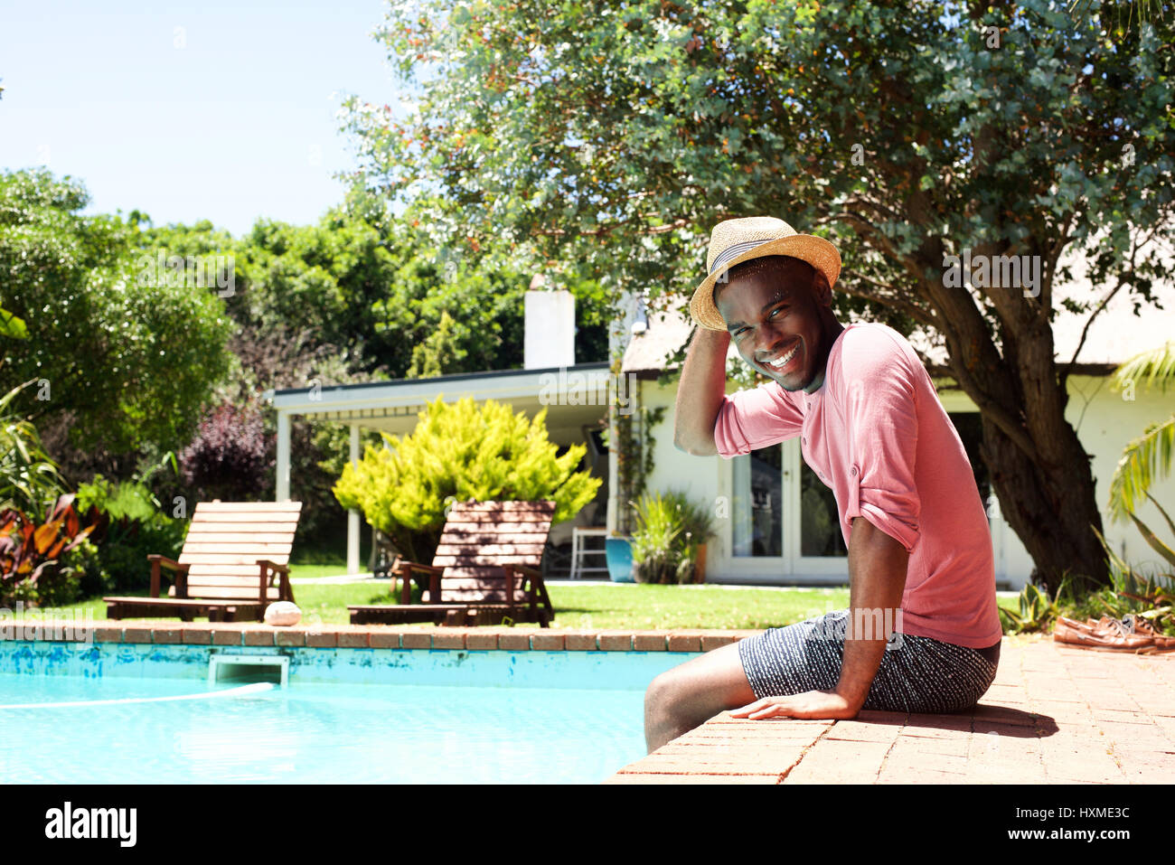 Portrait of relaxed young african man sitting on the edge of the ...