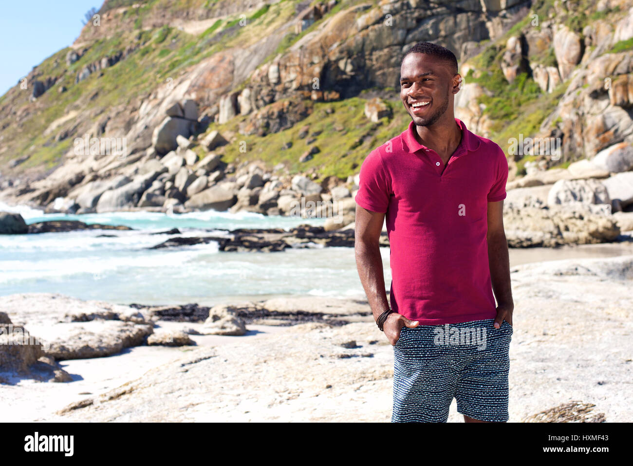 Portrait of cool young african guy smiling at the beach in summer Stock ...