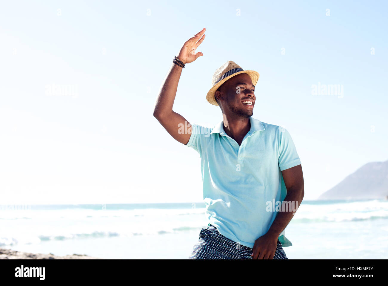 Portrait of cool young african man dancing at the beach on summer day ...