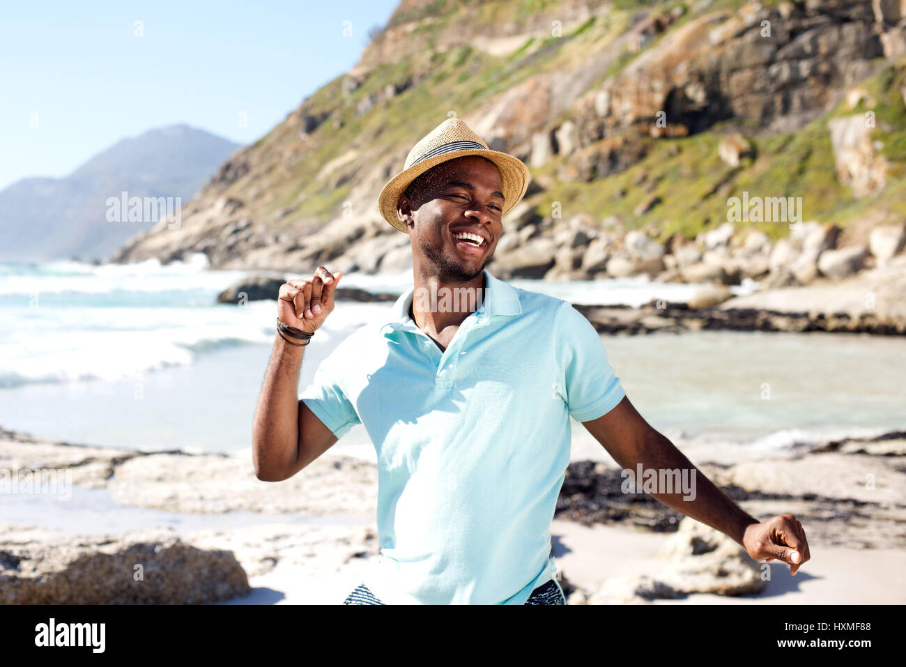 Portrait of young african man dancing at the beach on summer day Stock ...