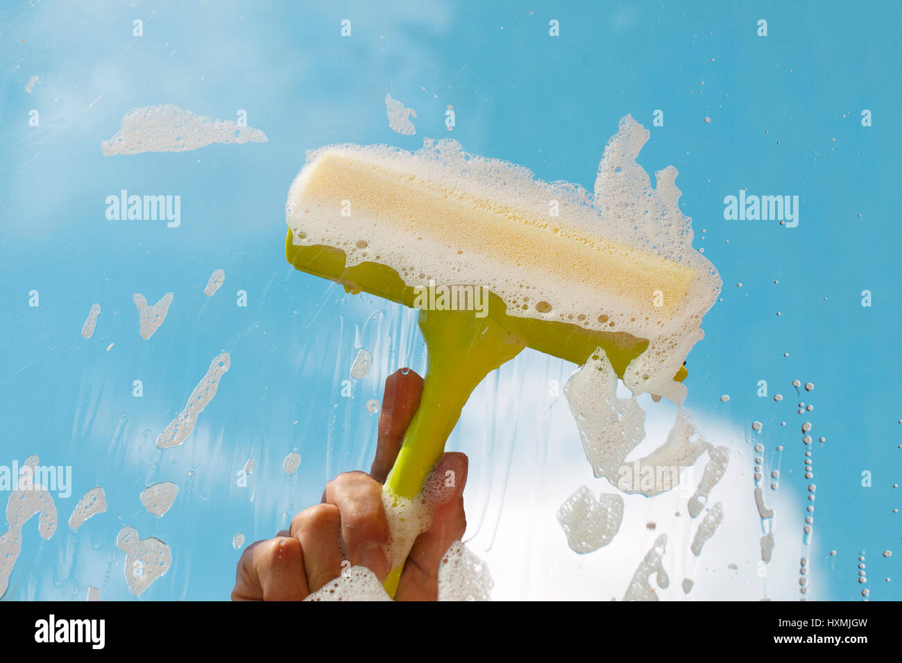 Hand cleaning window against blue sky Stock Photo - Alamy