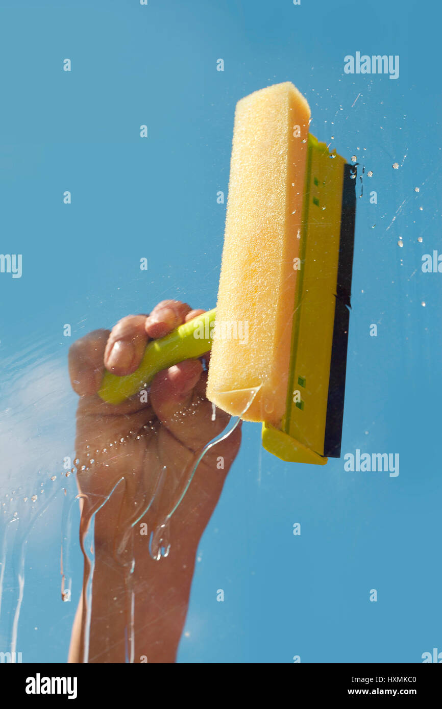 Hand cleaning window against blue sky Stock Photo - Alamy
