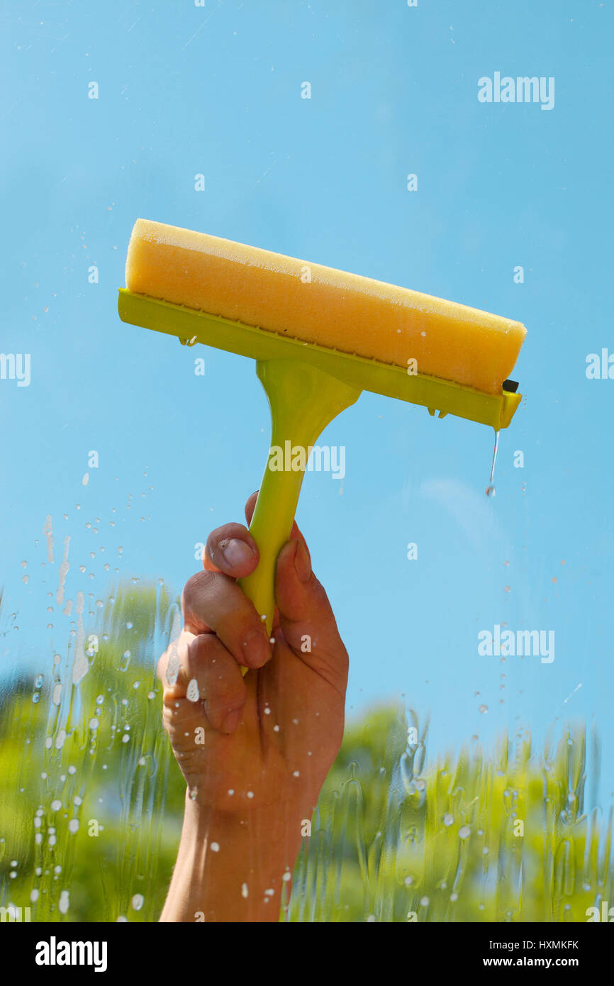 Hand cleaning window against blue sky Stock Photo - Alamy