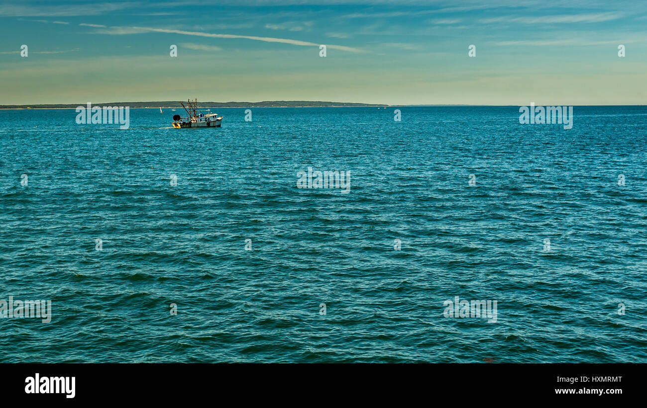 A fishing boat makes it way across Vineyard Sound from Falmouth towards ...