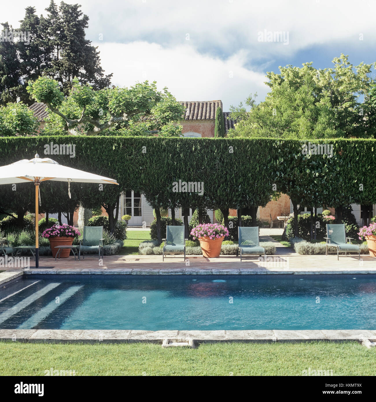 Loungers around a swimming pool Stock Photo - Alamy