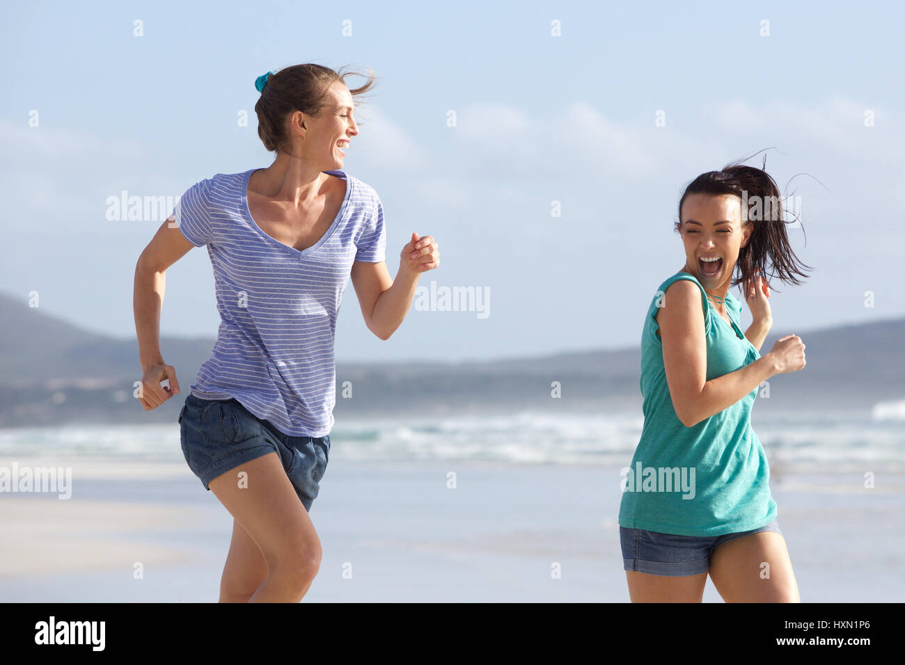 Portrait of two friends running in summer at the beach Stock Photo - Alamy
