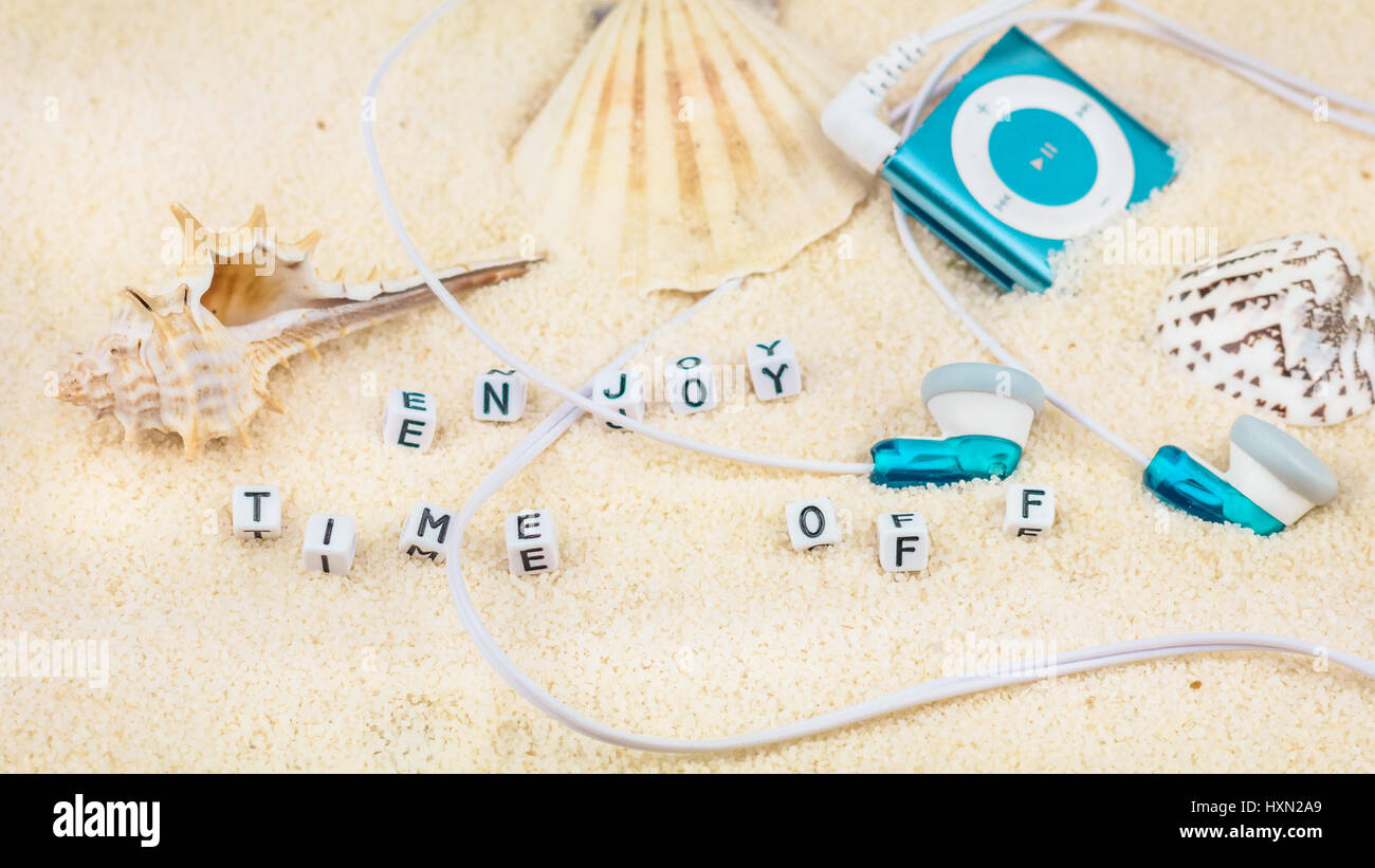 Enjoy time off letters between sea shells and audio player on sandy ...