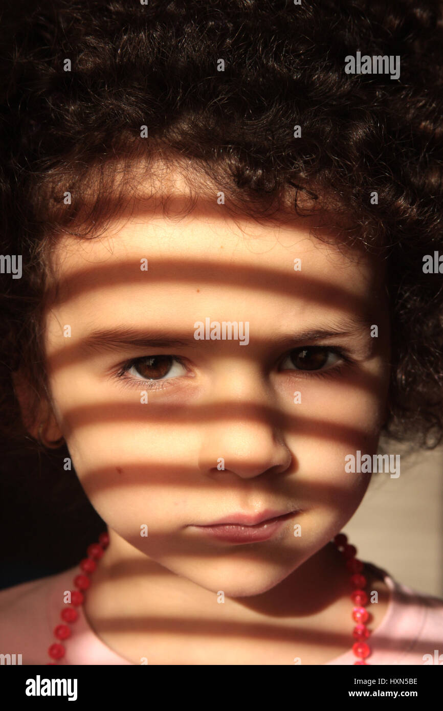 Portrait of little girl with lines reflecting on her face Stock Photo ...