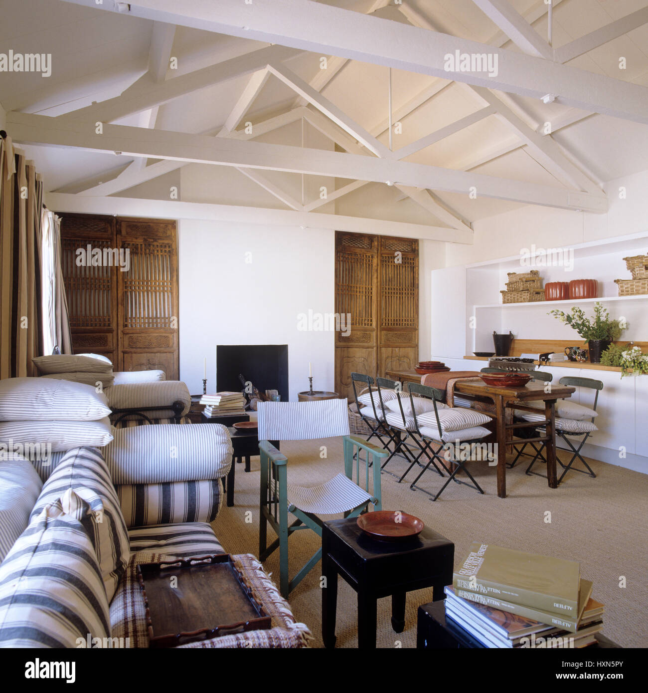 Sofa and dining area in room with beamed ceiling Stock Photo - Alamy