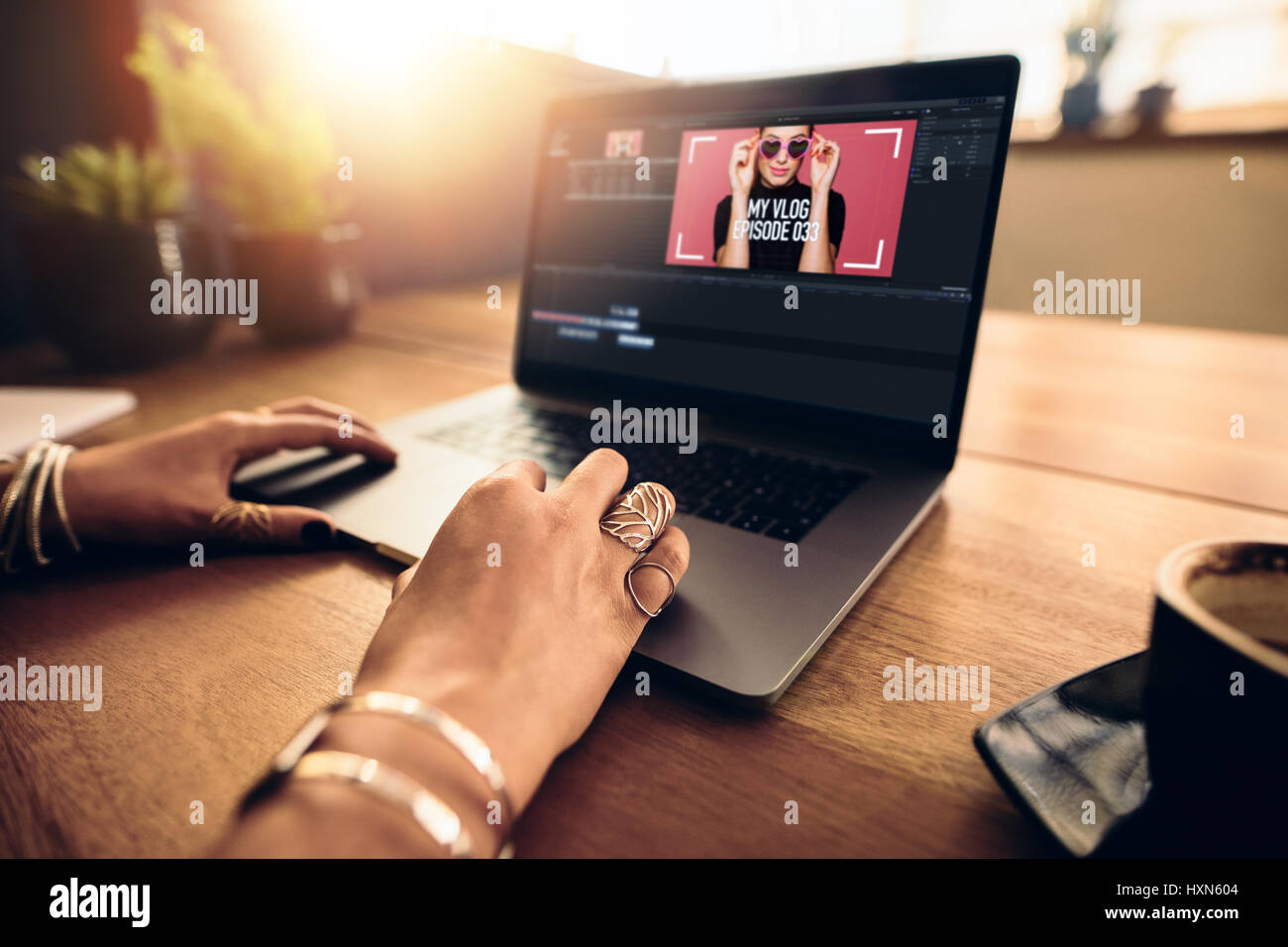Woman editing video on laptop computer for her vlog. Woman wearing ...