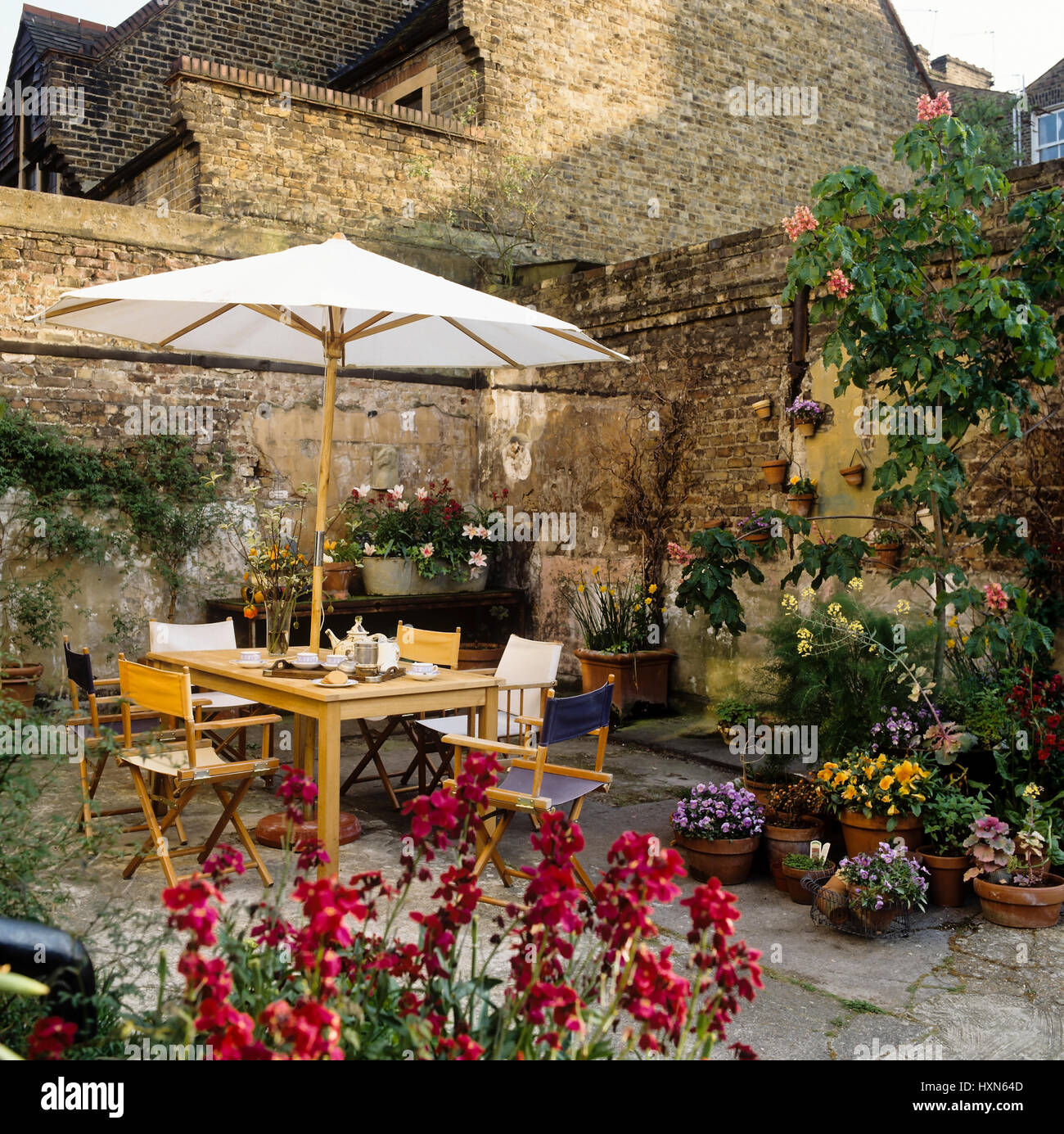 Table and chairs under sun umbrella Stock Photo - Alamy