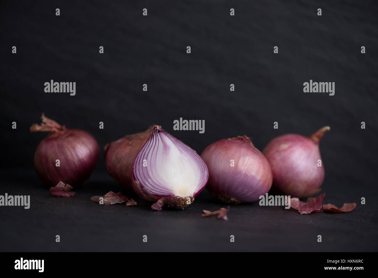 Full and half cut spanish onions on dark background Stock Photo - Alamy