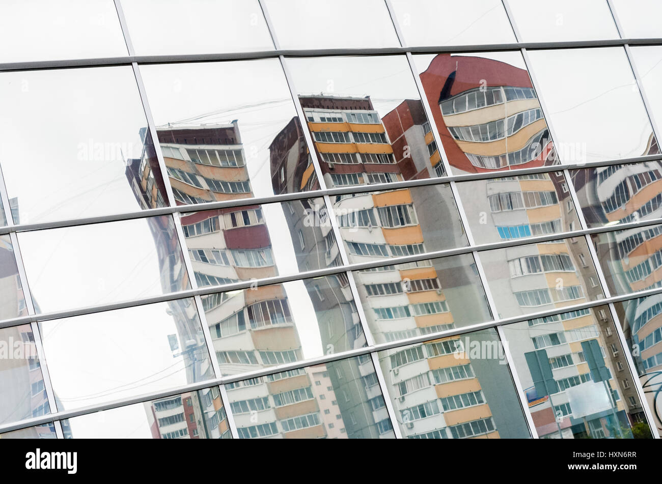 Distorted reflection of houses in mirror surface of facing of shopping ...