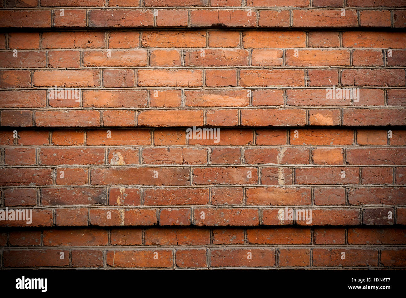 Part of old brick wall lined with steps across five rows of brickwork ...