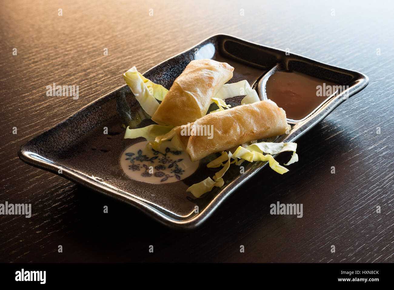 Fried spring rolls with vegetables, served on rectangular ceramic plate ...
