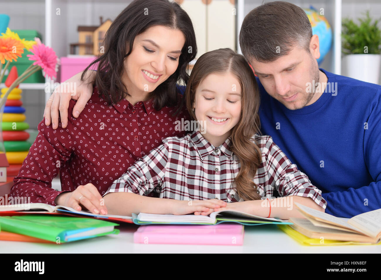 Parents helping daughter with lessons Stock Photo - Alamy