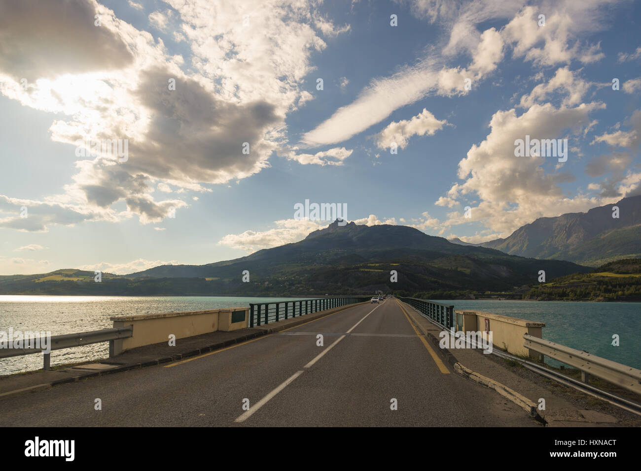 Paved two lane road on bridge crossing lake in scenic landscape and ...