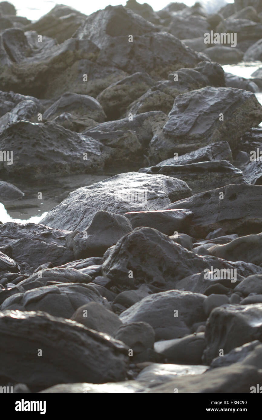 Rocks and cliffs inside the ocean at sunset Stock Photo - Alamy
