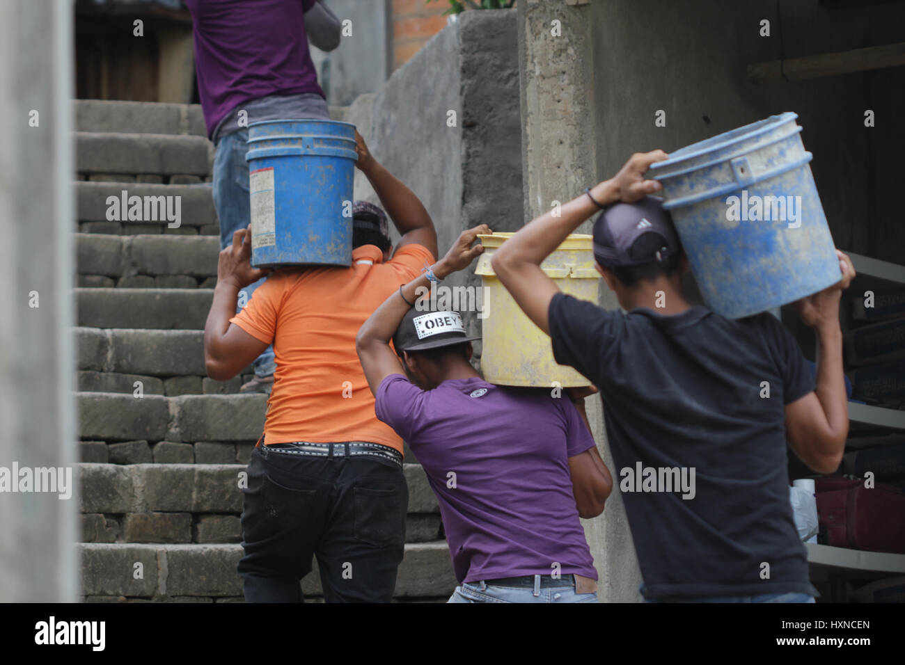 People are carrying heavy big buckets with some material inside Stock ...