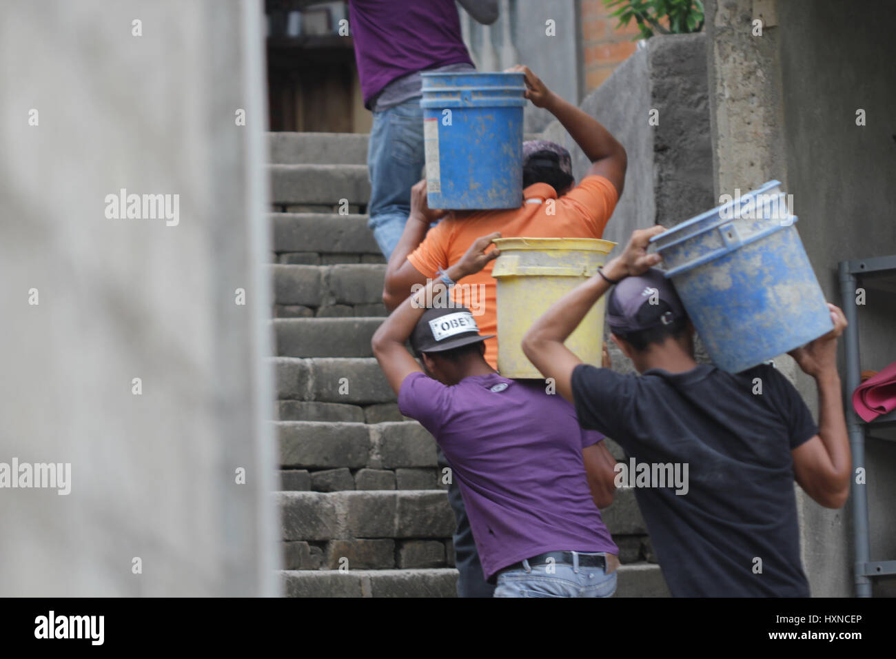 People are carrying heavy big buckets with some material inside Stock ...