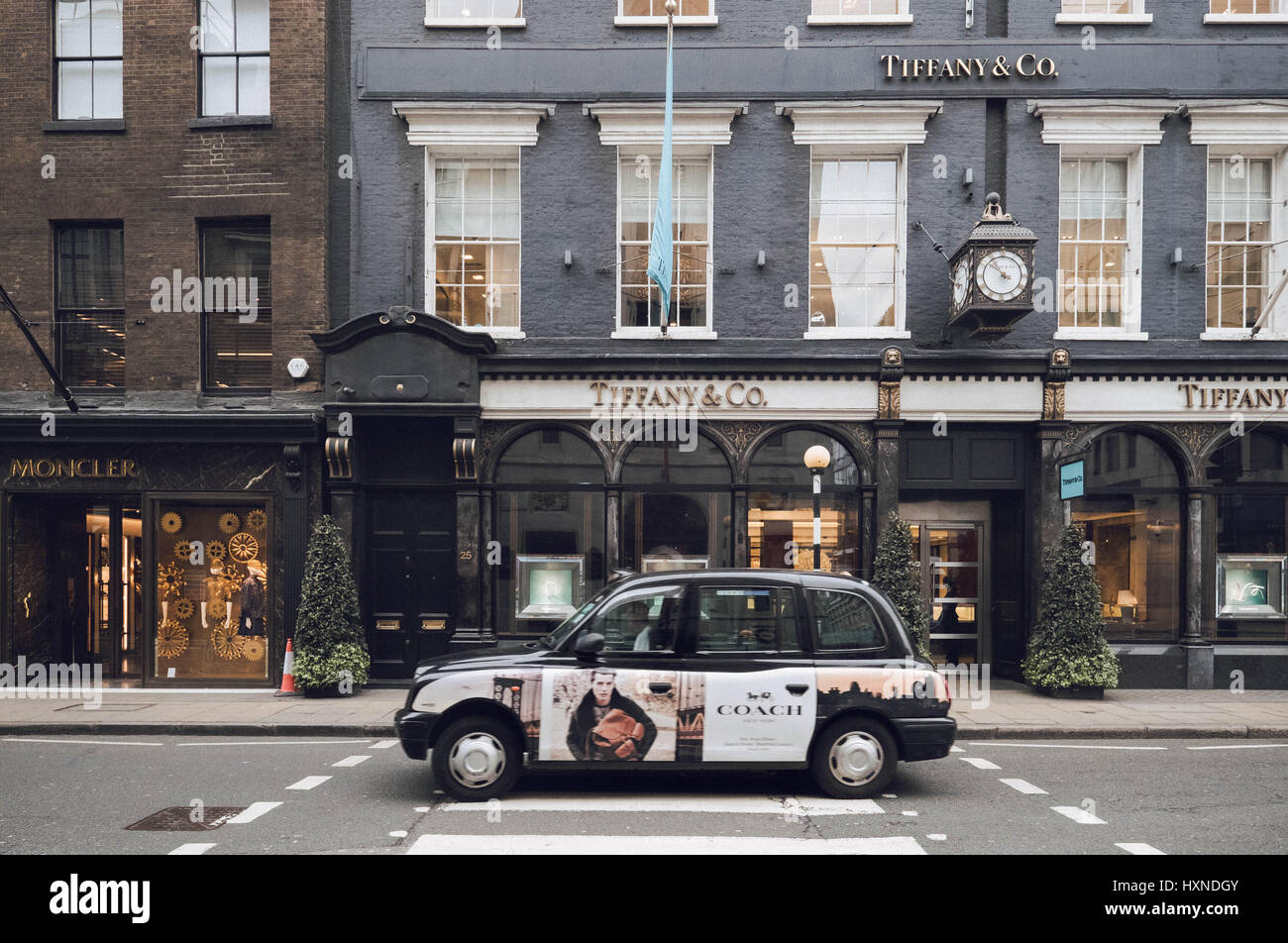 Transport: A black London taxi / cab drives past Tiffany & Co luxury ...