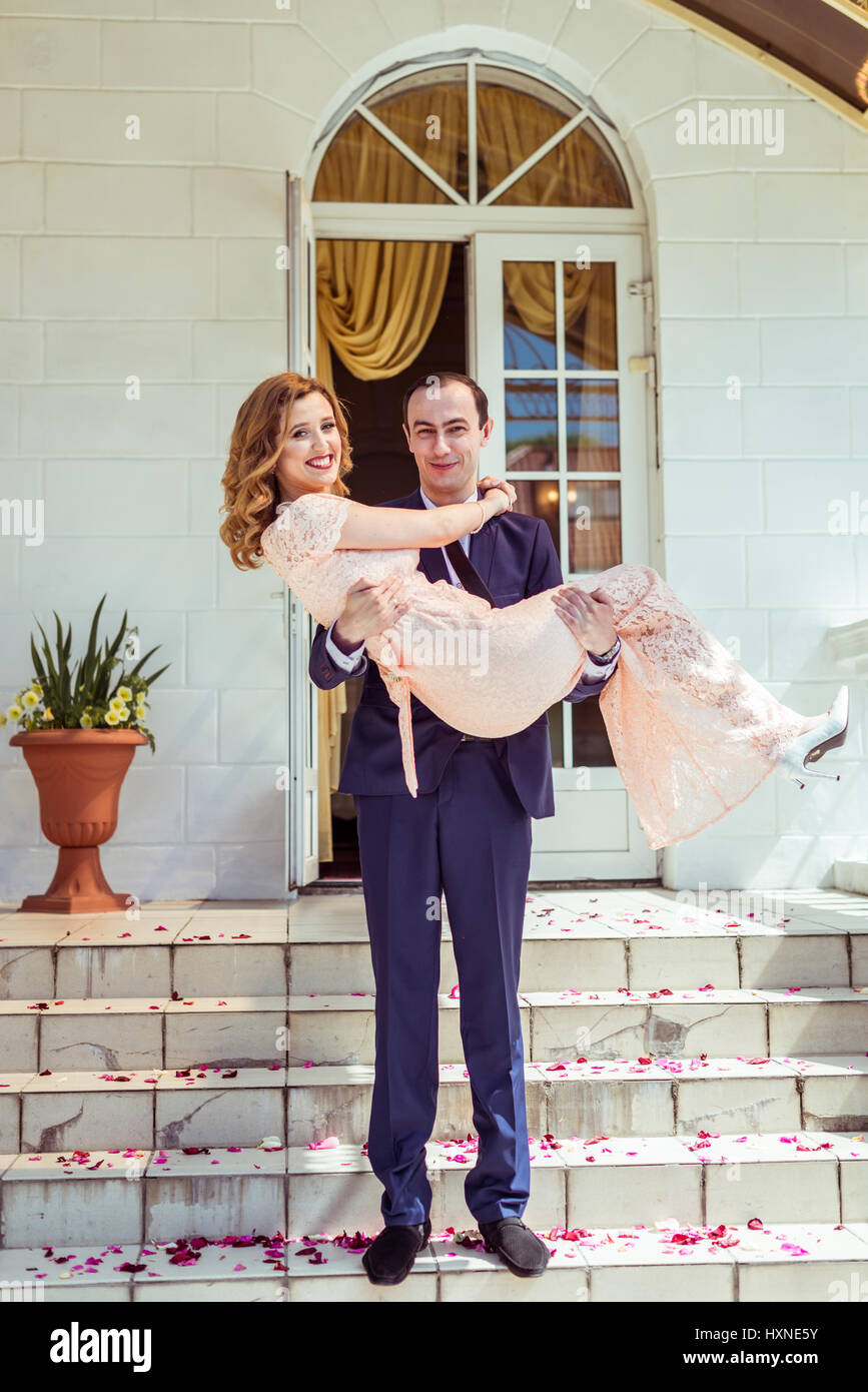 Groom holding bride in his arms Stock Photo - Alamy