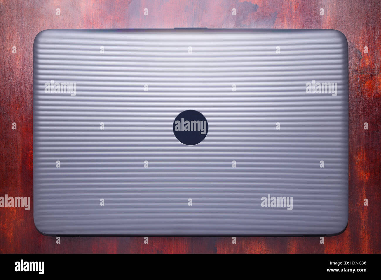 Closed laptop lying on a wooden surface mahogany Stock Photo - Alamy